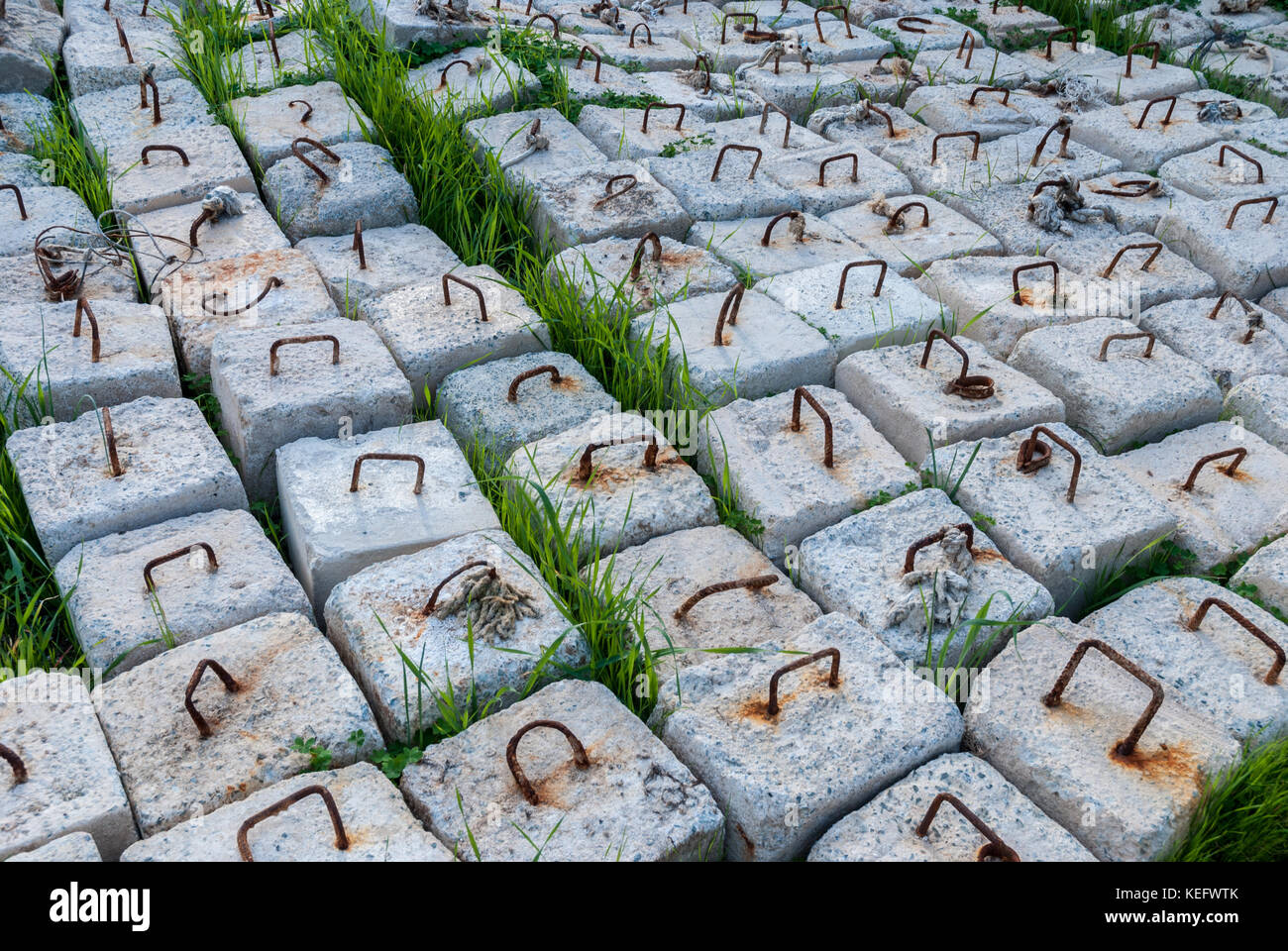 Multi colored sea buoys (beacons) and weights stored on land with green ...