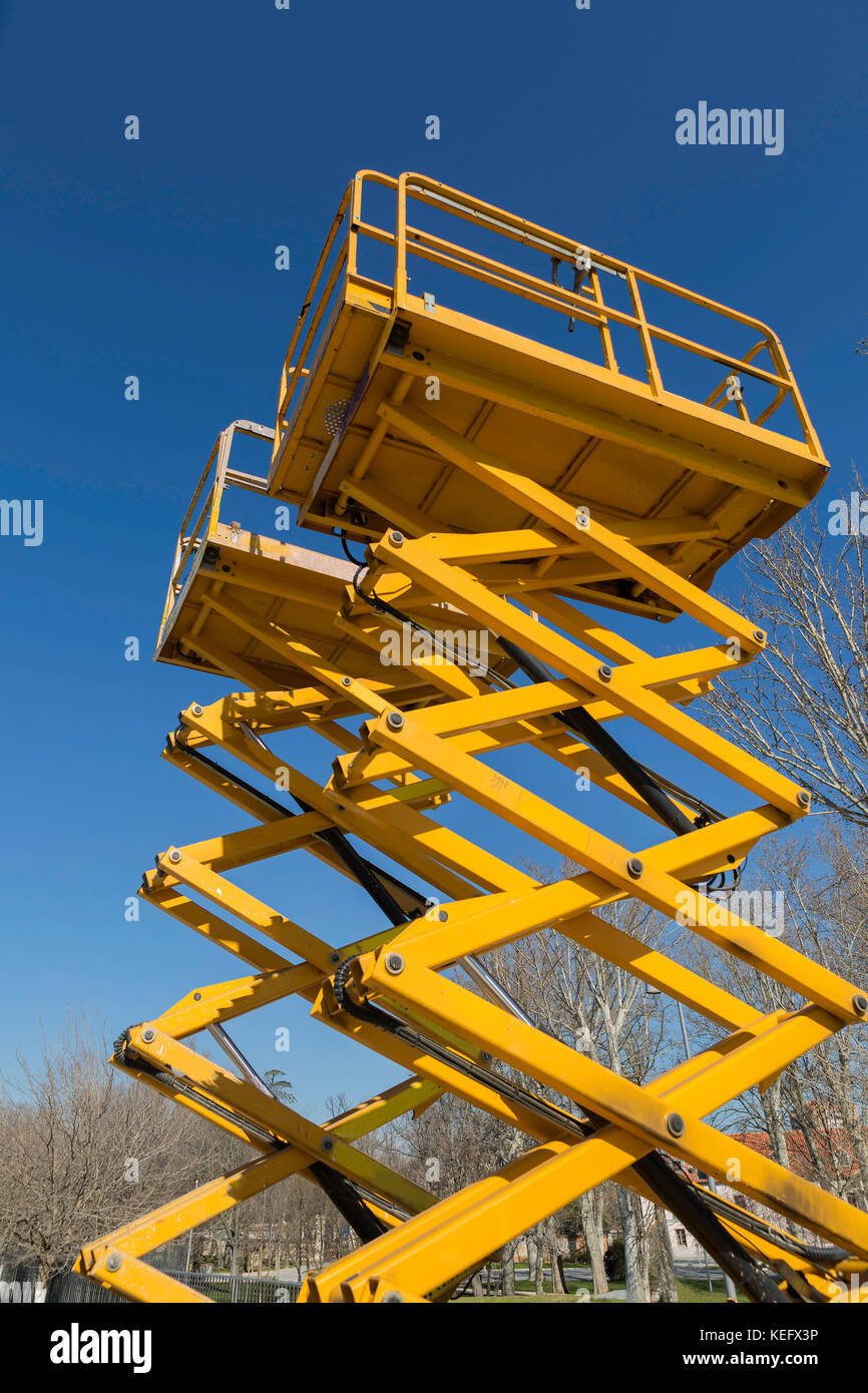 yellow platform lift in the forest to prune trees Stock Photo - Alamy