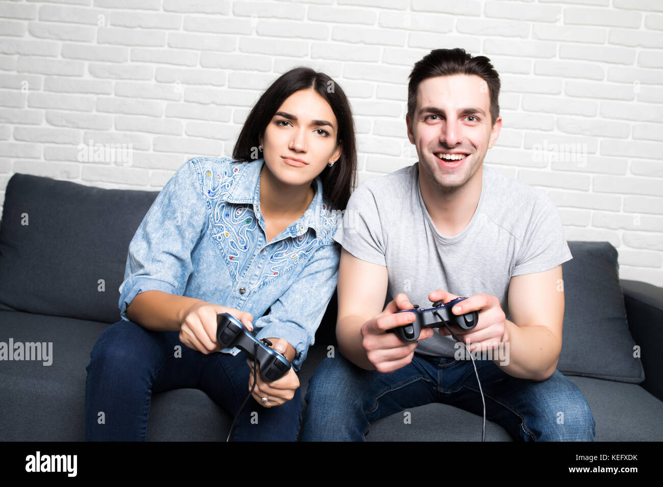 Beautiful couple playing video games on console having fun Stock Photo ...