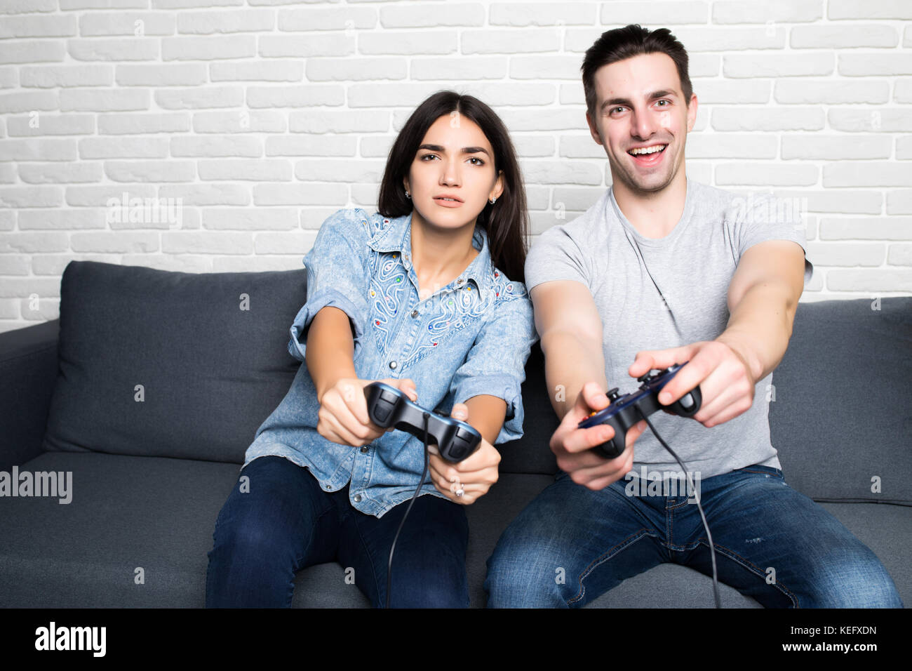 Young couple playing video games at home Stock Photo - Alamy
