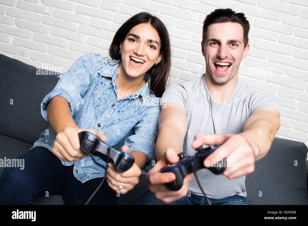 Young couple having fun playing videogame at home Stock Photo - Alamy