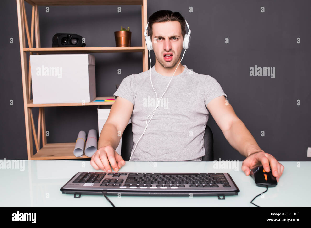 angry screaming young man in headset with pc computer playing game at ...