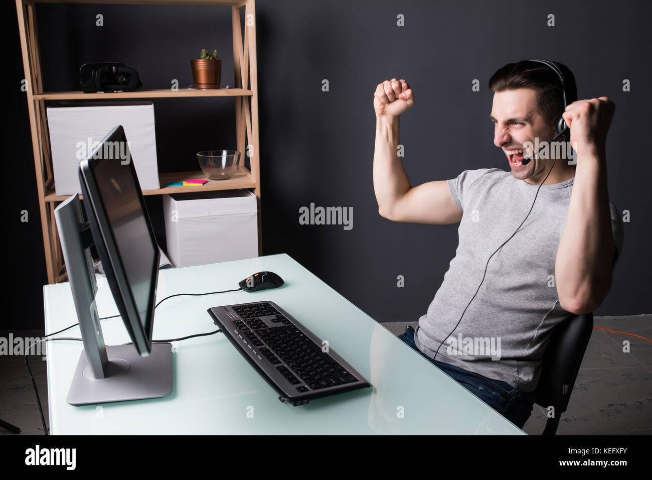 Euphoric winner happy man using a pc in a desk at home Stock Photo - Alamy