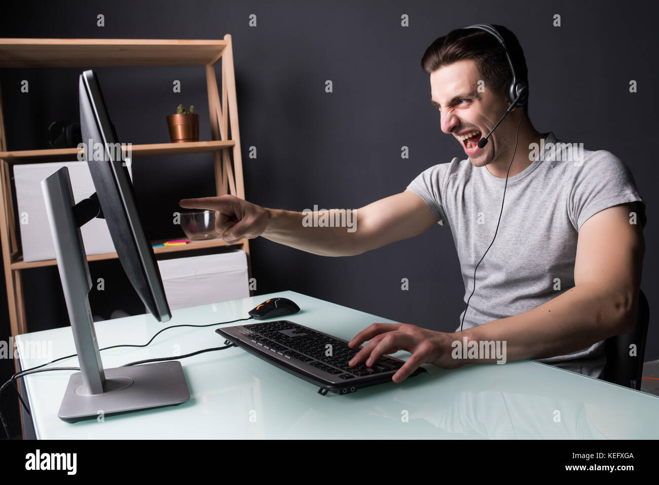 Young man playing computer games in dark room Stock Photo - Alamy
