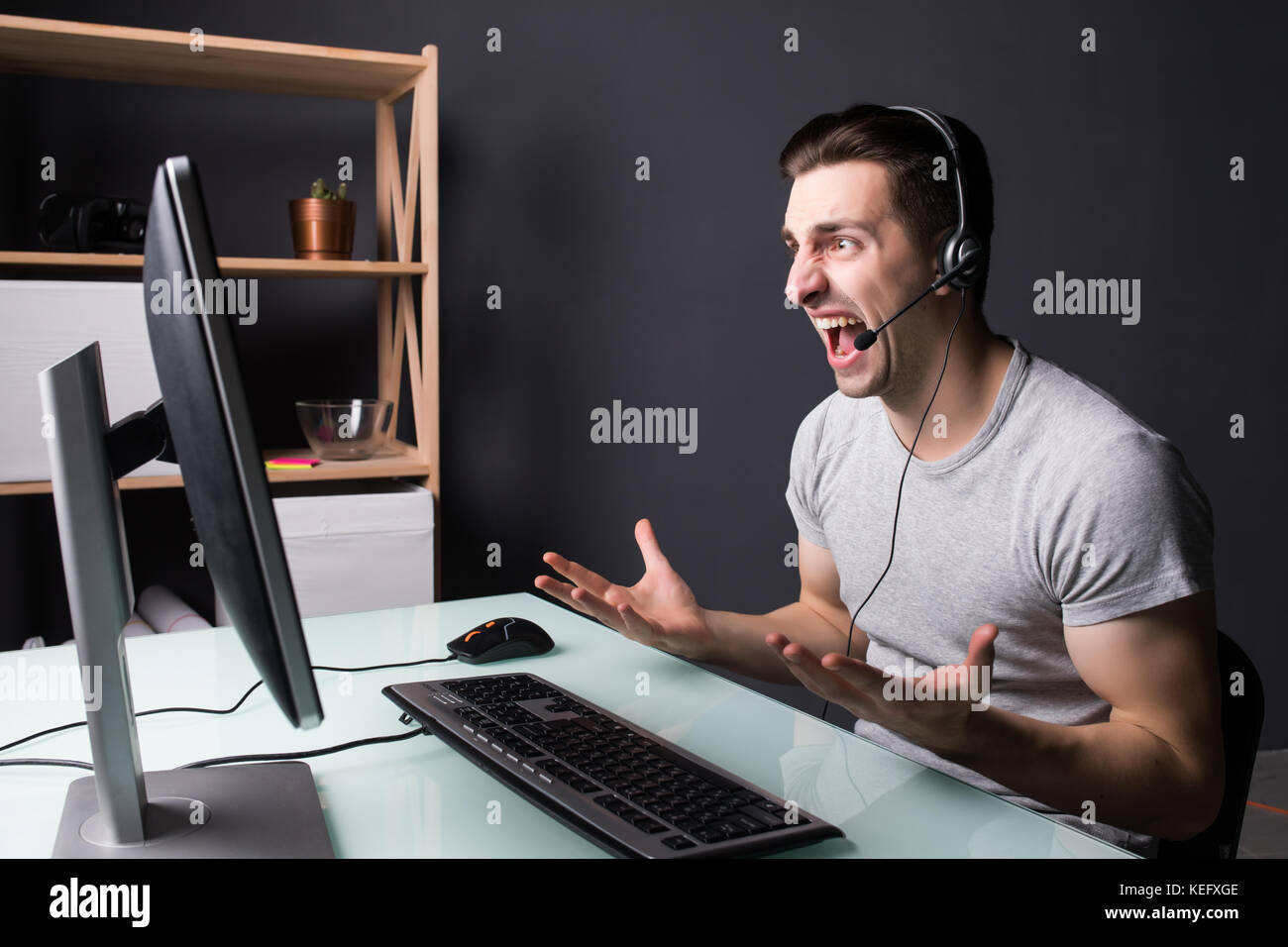 Young man playing computer games in dark room Stock Photo - Alamy