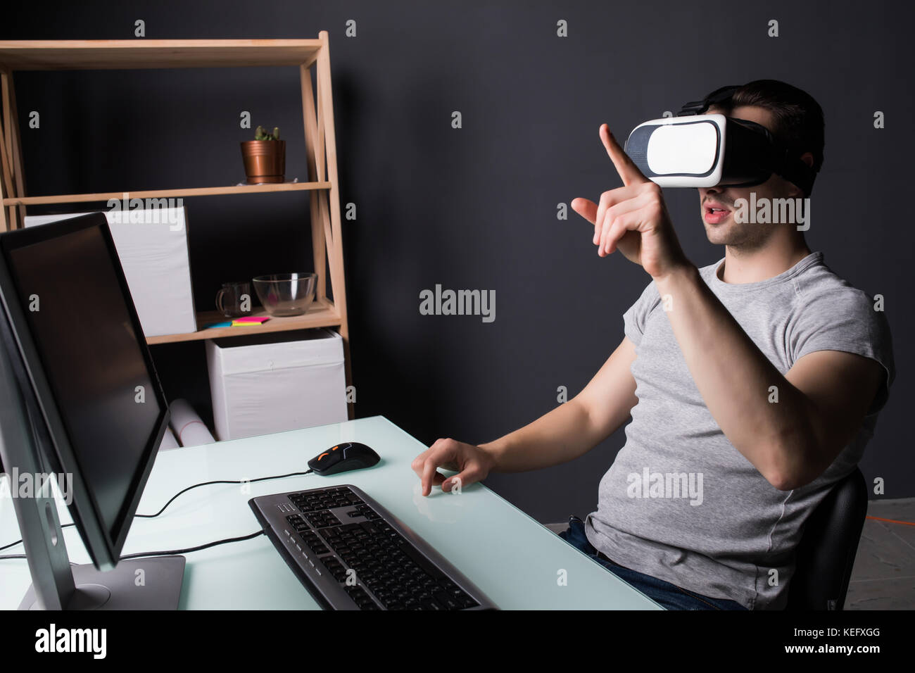 Side view of a man having a VR experience and pointing with the finger ...