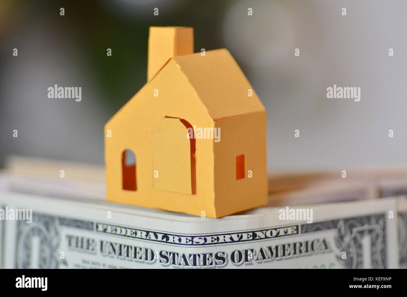 Paper made house stands on dollar money Stock Photo - Alamy