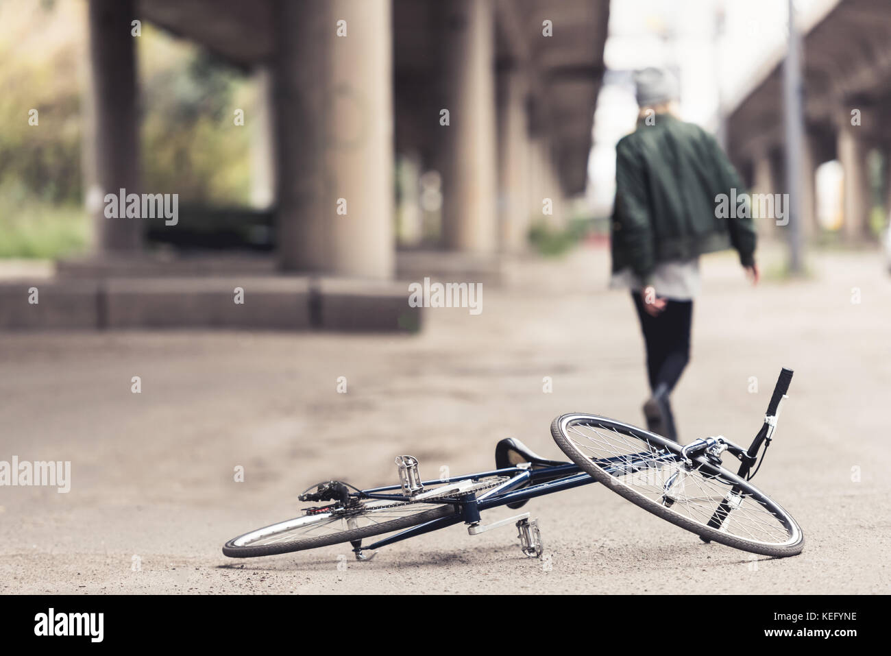 woman walking away from vintage bicycle laying on asphalt Stock Photo ...