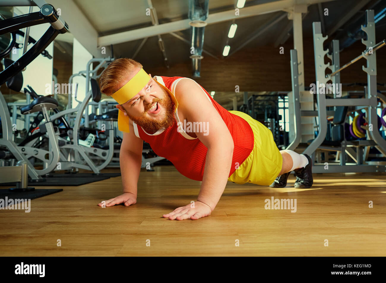 A fat man does push-ups from the floor in the gym Stock Photo - Alamy