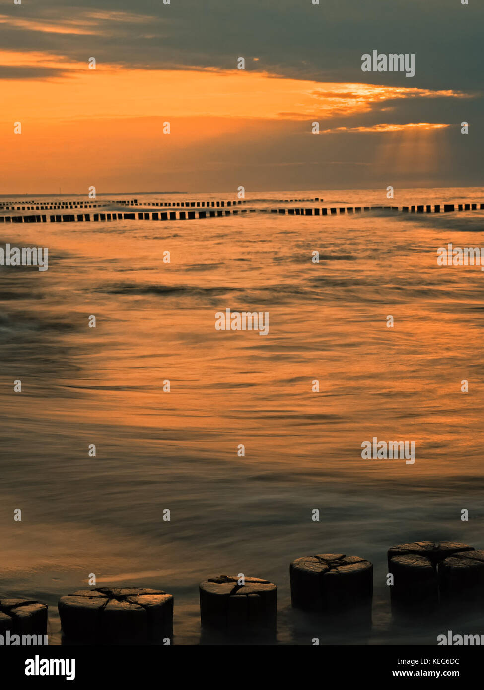 Baltic Sea with breakwaters at sunset Stock Photo - Alamy