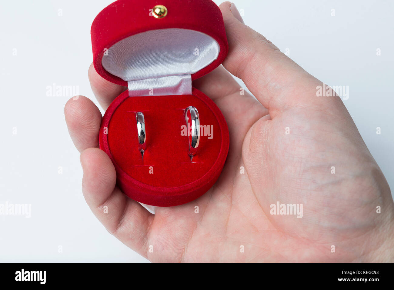 Human hand holding a gift box with engagement ring inside on white ...