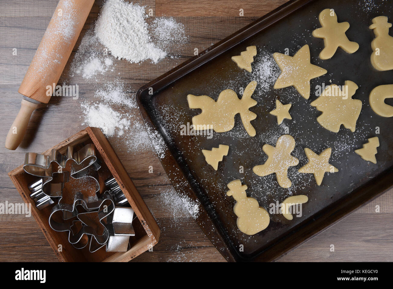 Top view of a baking sheet with a holiday shaped sugar cookies, with a ...
