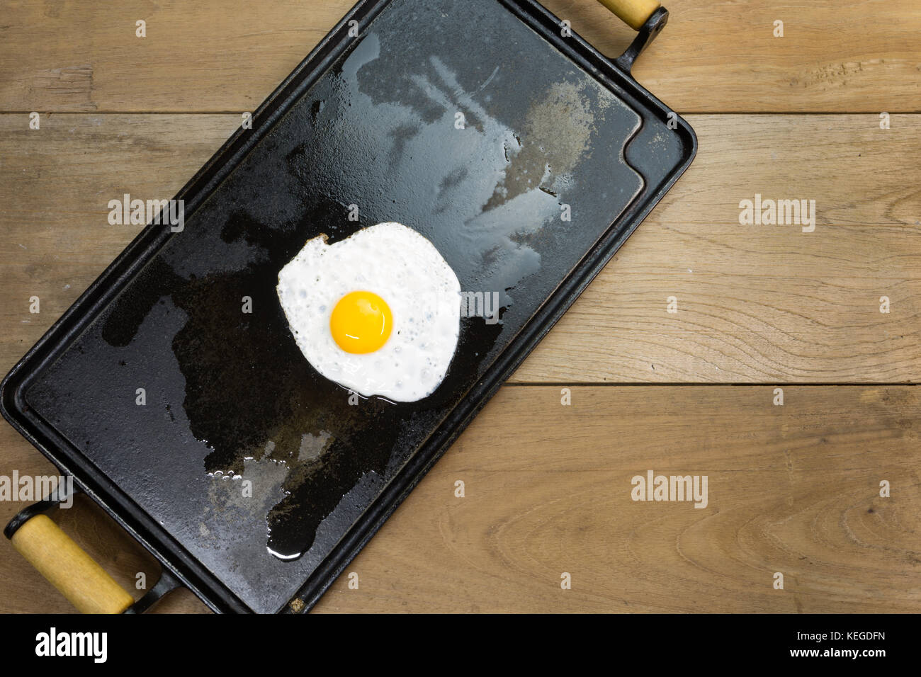 Fried egg white and yolk rectangular cast iron flat griddle pan with ...