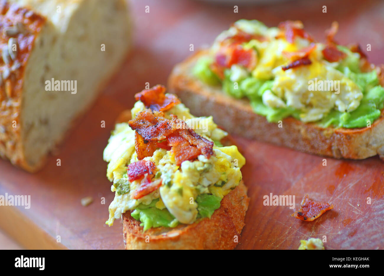 Toasted whole grain bread with avocado, scrambled eggs and bacon Stock ...