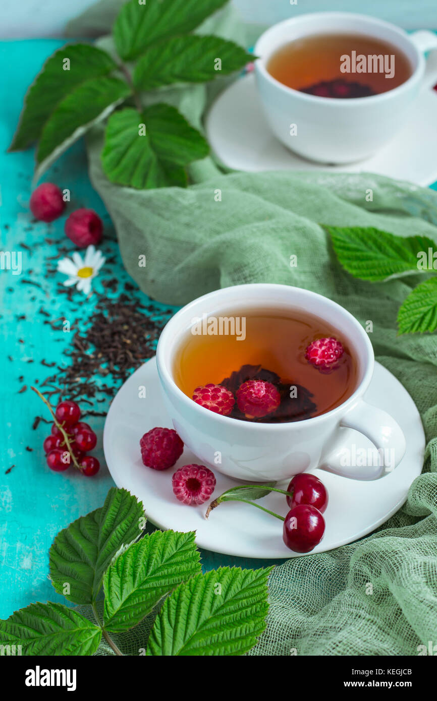 Tea with summer berries on turquoise background selective focus Stock ...