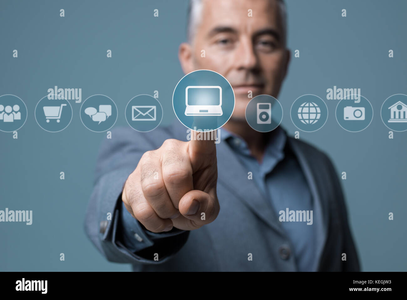 Businessman using a visual interactive interface with icons, he is ...