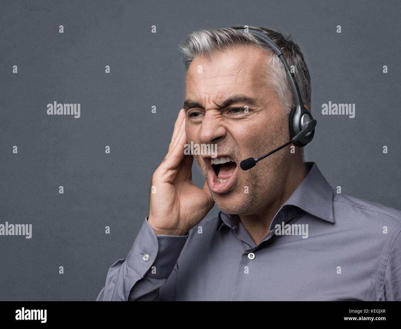 Angry aggressive customer support phone operator with headset, he is ...