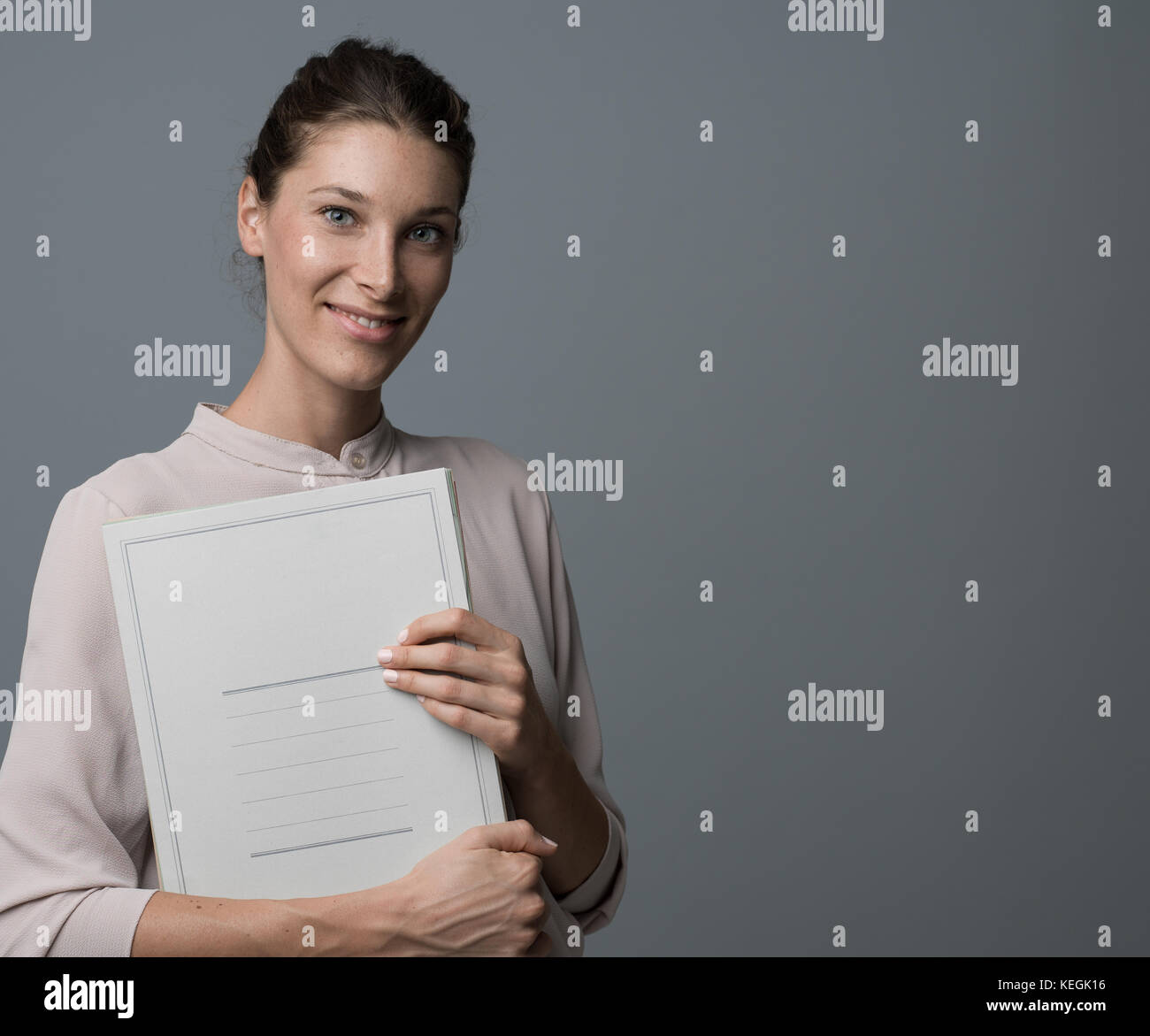 Professional female businesswoman holding paperwork and smiling at ...