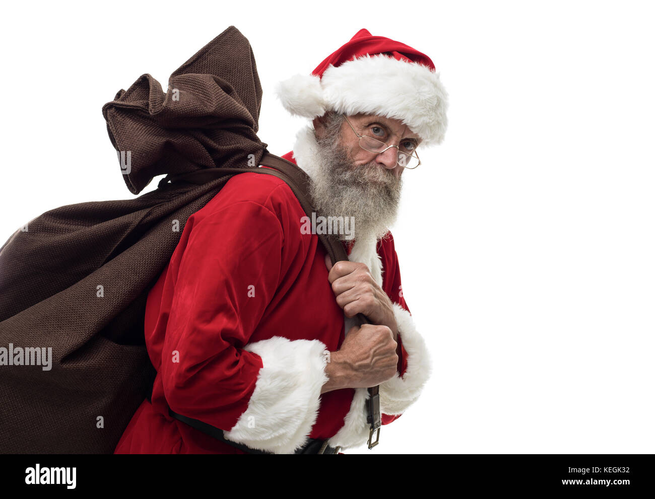 Happy Santa Claus carrying an heavy sack with Christmas gifts, white ...