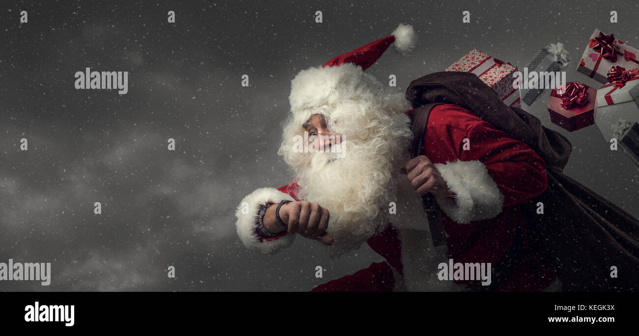 Santa Claus running and delivering Christmas presents: he is late and ...