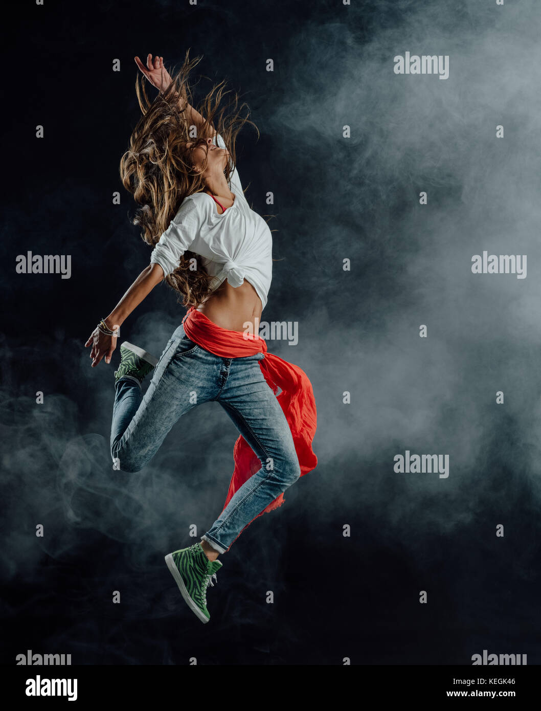Female modern style performer dancing on dark background, she is ...