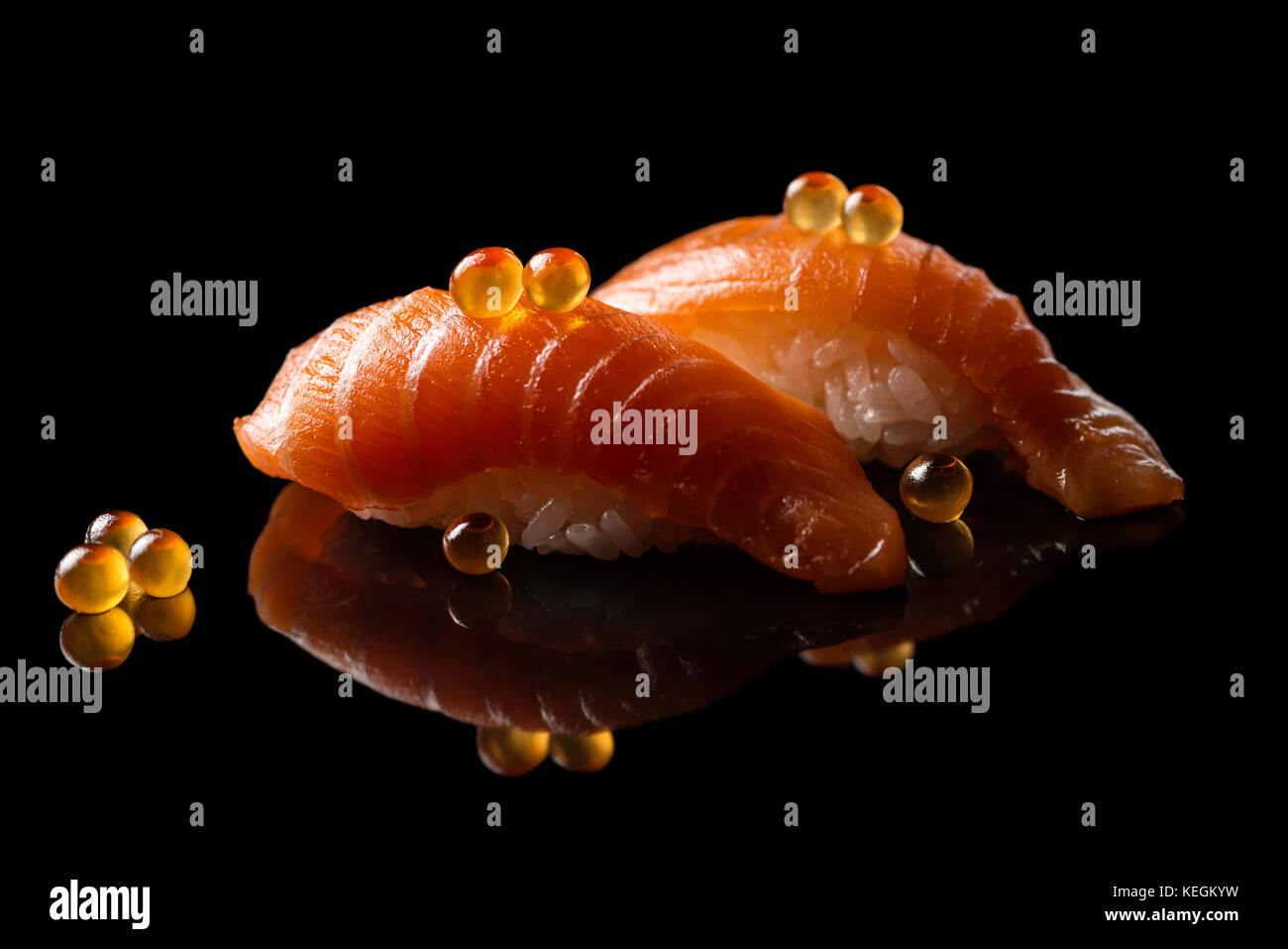 two closeup of fresh salmon sashimi sushi with caviar isolated on a ...