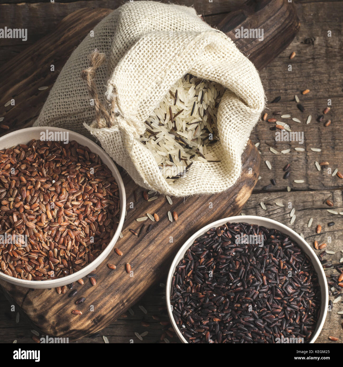 Selection of red, black and mixed rice on an old wooden background ...