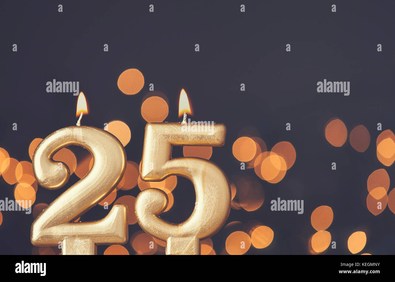 Gold number 25 celebration candle against blurred light background ...