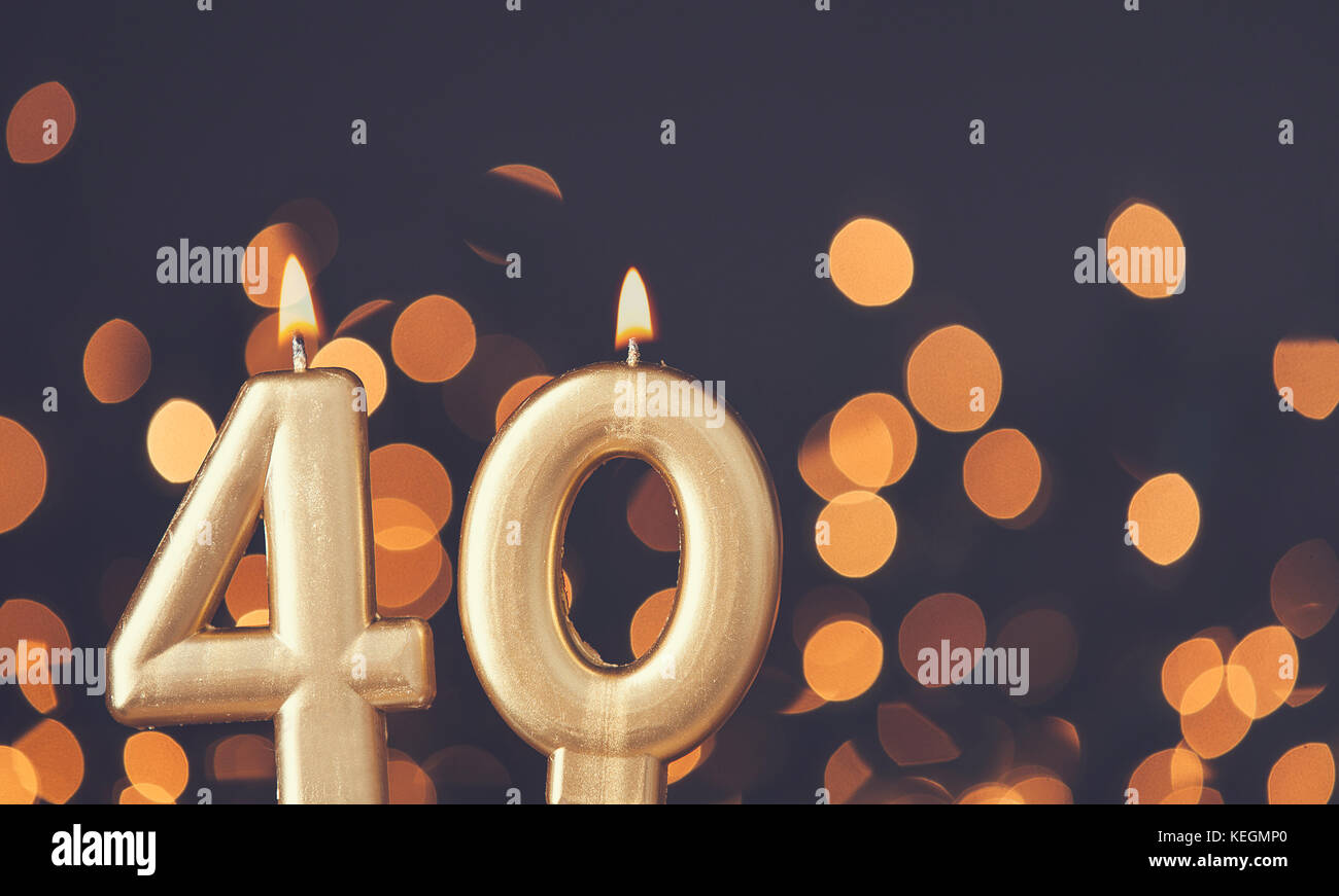 Gold number 40 celebration candle against blurred light background ...