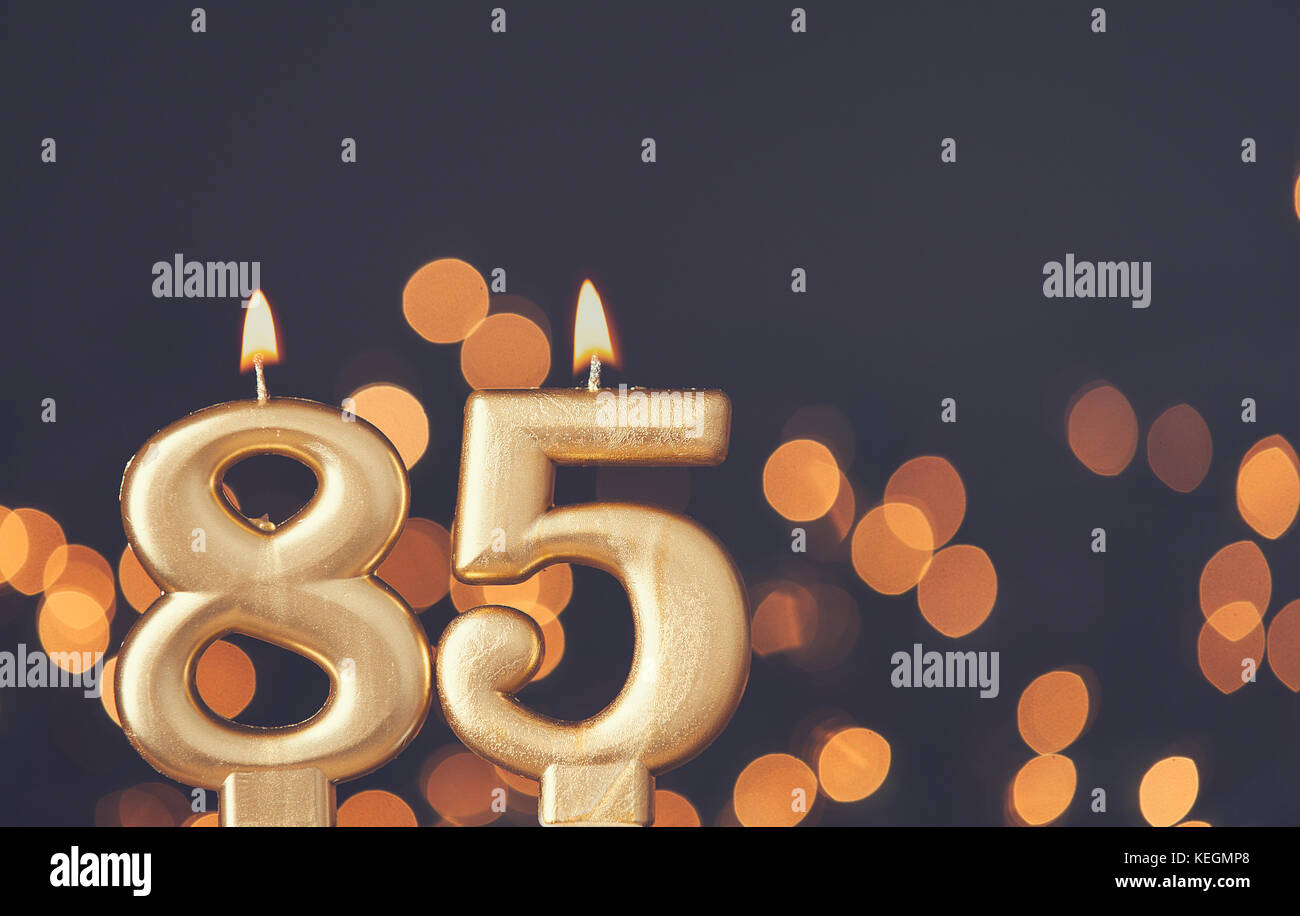 Gold number 85 celebration candle against blurred light background ...