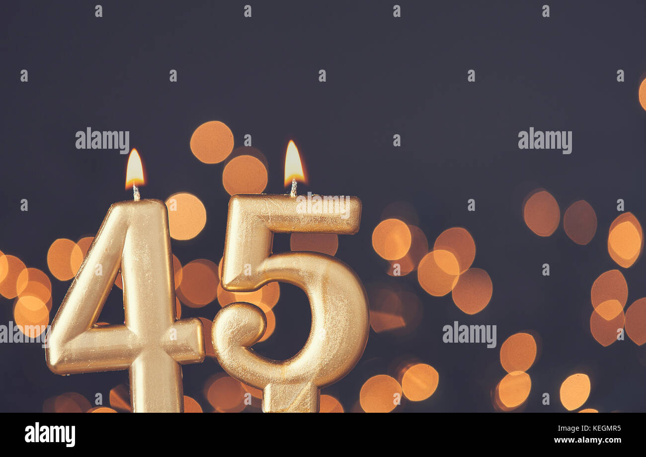 Gold number 45 celebration candle against blurred light background ...