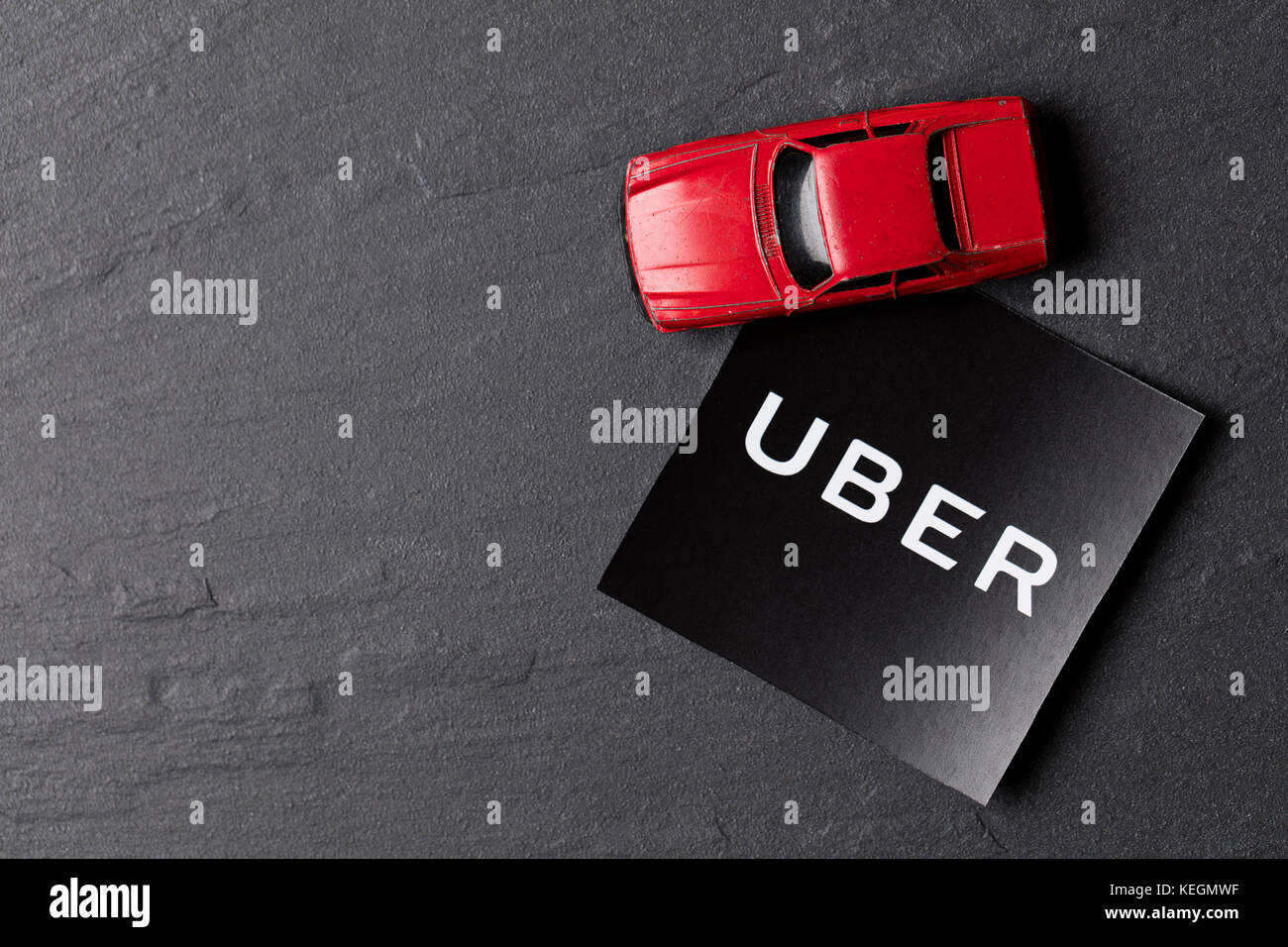A photograph of the Uber logo and toy car. Uber is a popular taxi style ...
