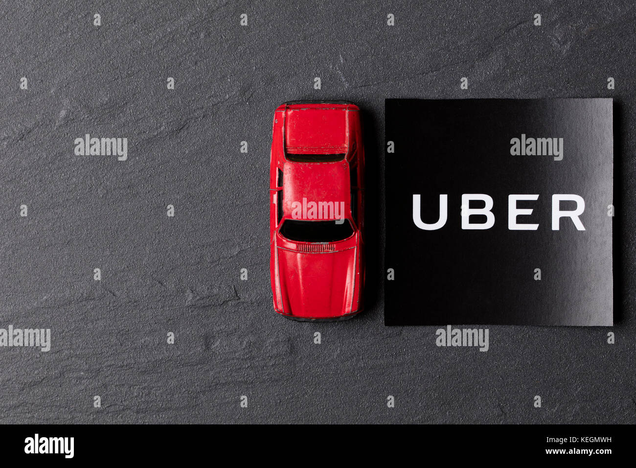 A photograph of the Uber logo and toy car. Uber is a popular taxi style ...