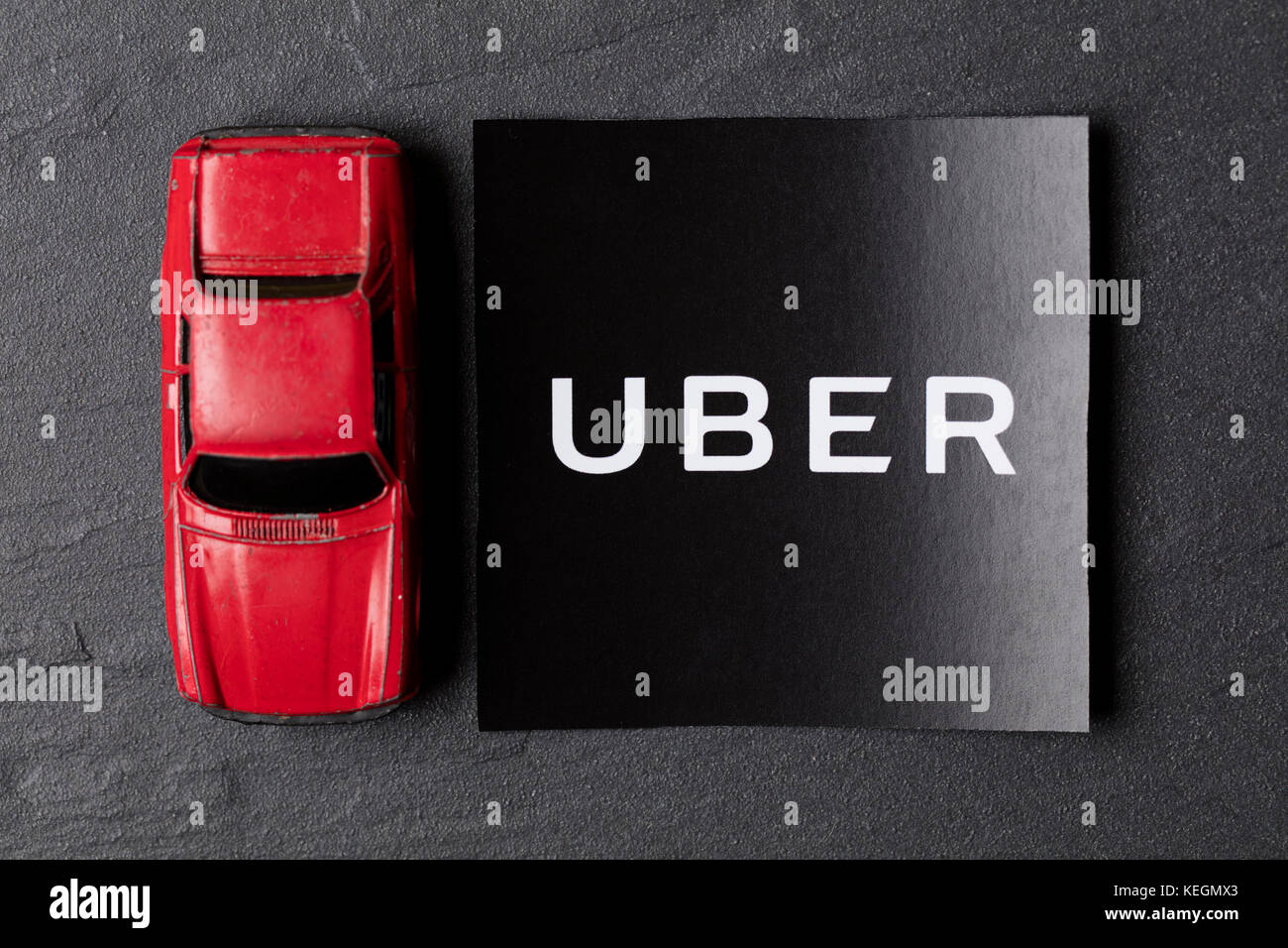 A photograph of the Uber logo and toy car. Uber is a popular taxi style ...