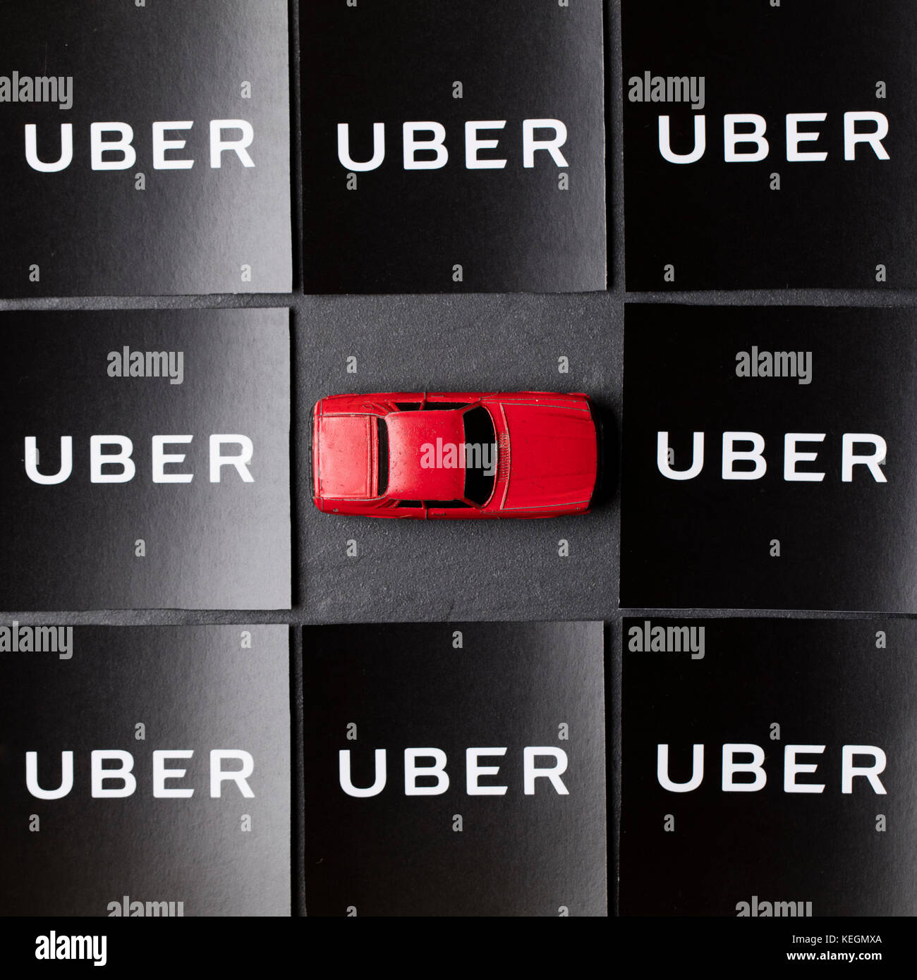 A photograph of the Uber logo and toy car. Uber is a popular taxi style ...