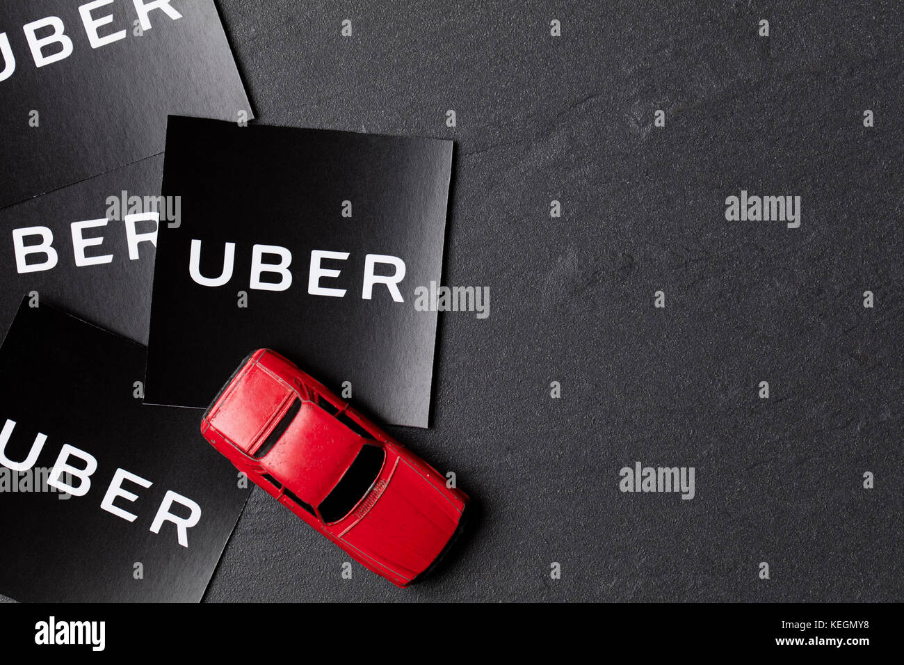 A photograph of the Uber logo and toy car. Uber is a popular taxi style ...