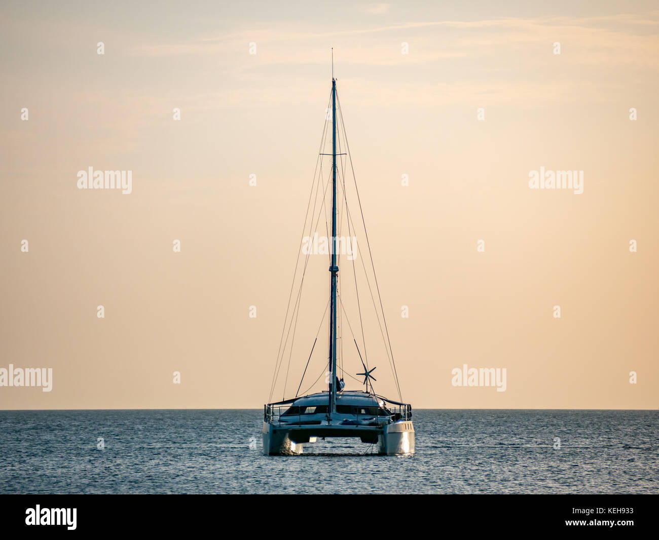 Sailing Boat and Catamaran at Sunset Stock Photo - Alamy