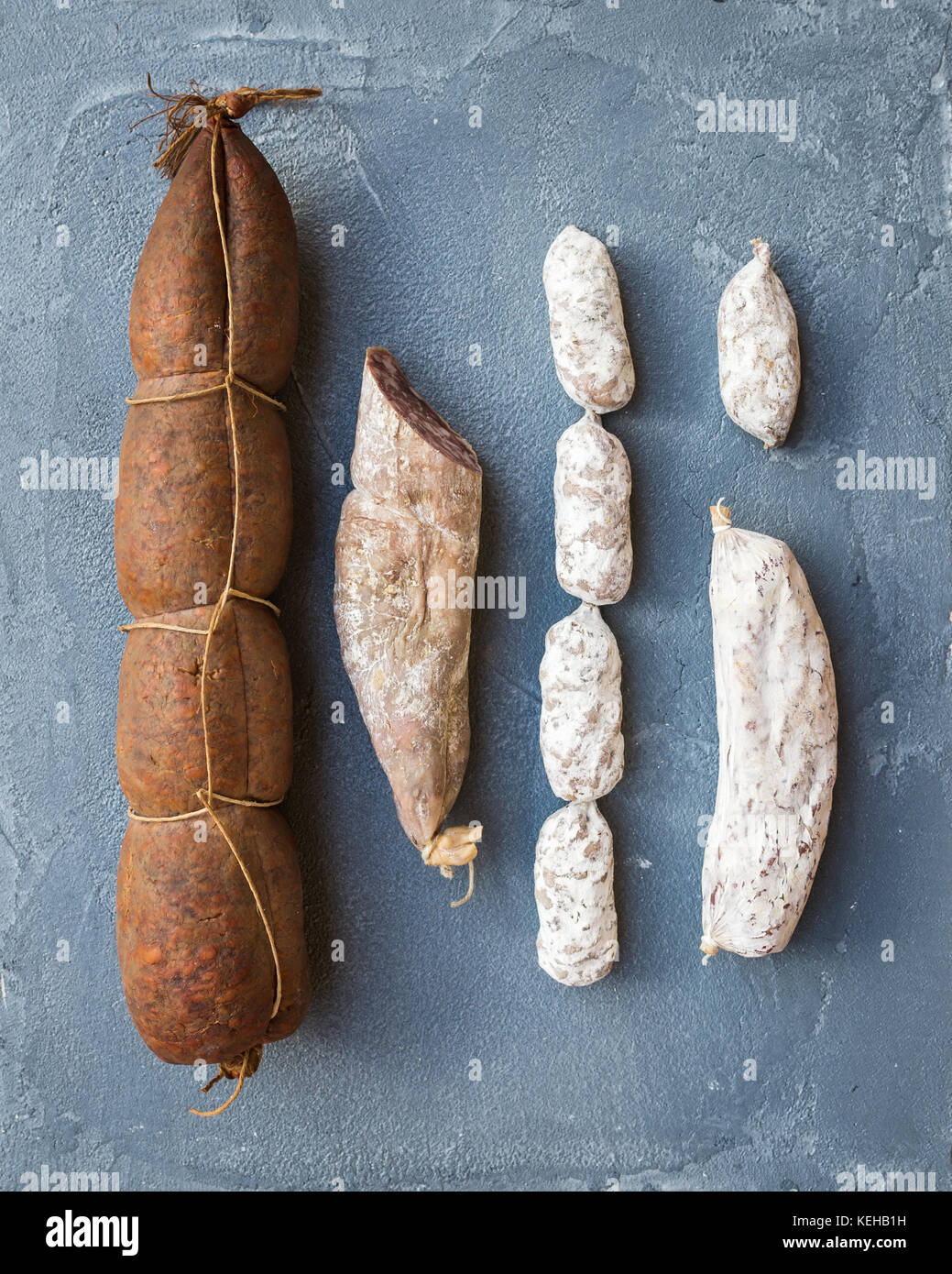 Italian slami sausages of different kinds over a rough grey-blue ...