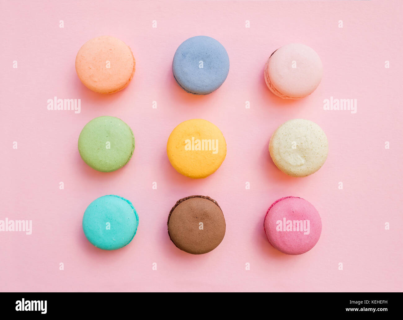 Sweet colorful French macaroon biscuits on pastel pink background, top ...