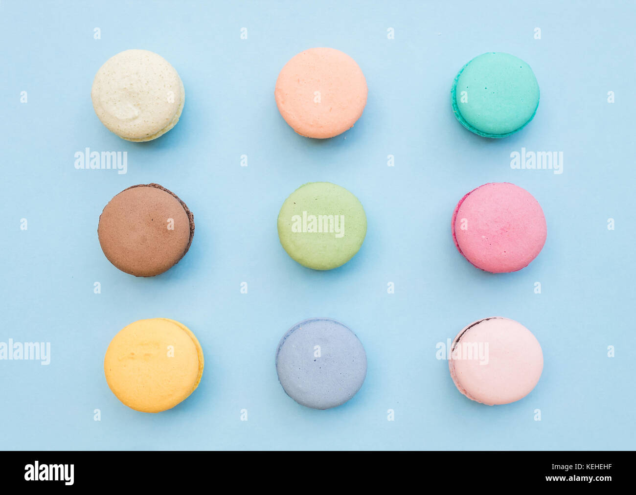 Sweet colorful French macaroon biscuits on pastel blue background, top ...