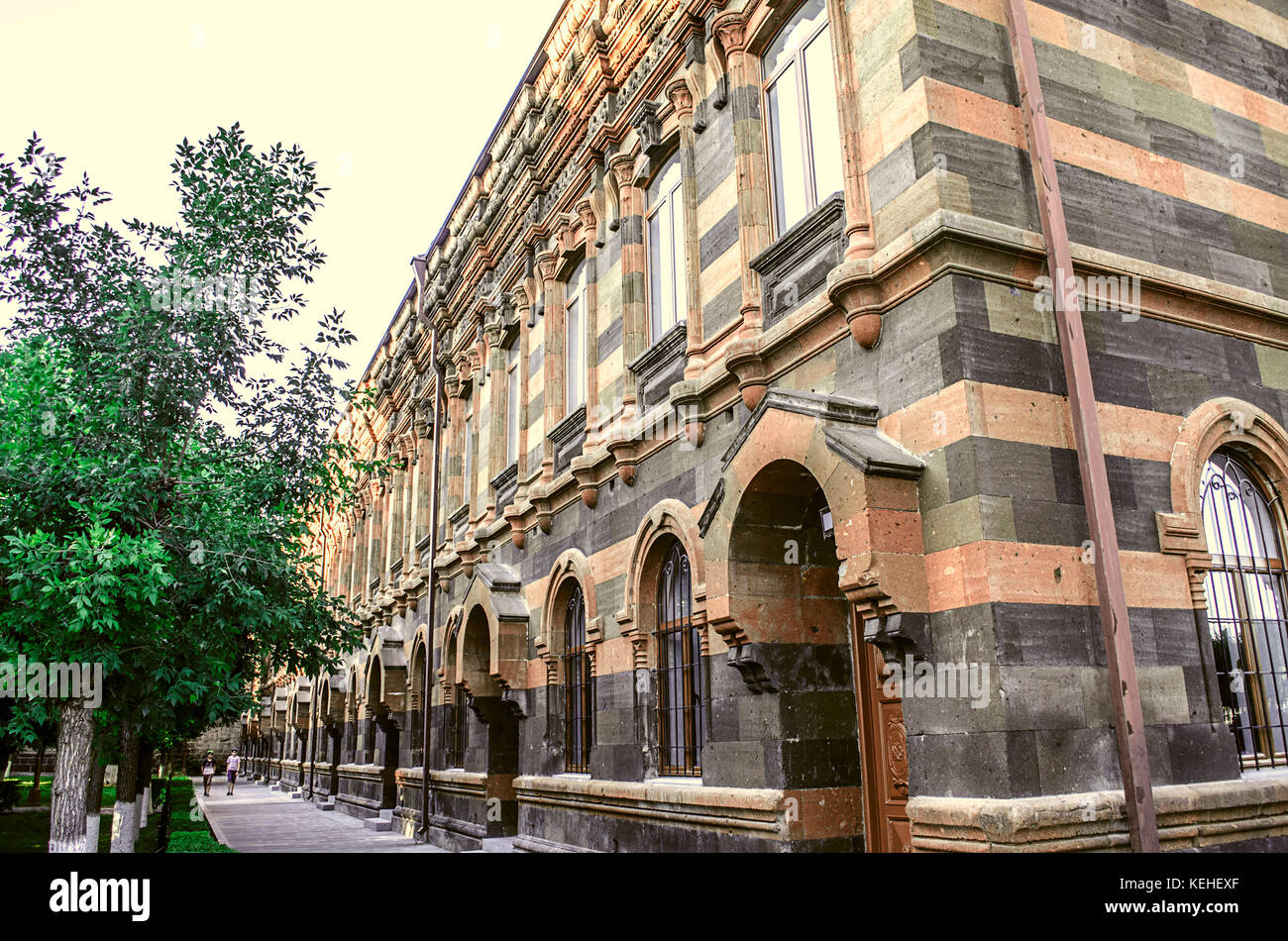 View from the side on the facade of old building of multi-colored tufa ...