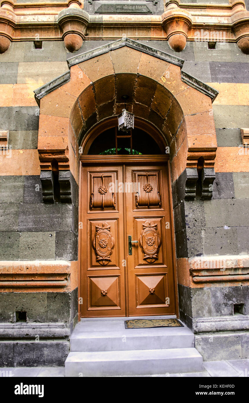 Stone arched visor with a console over the wooden door on the facade of ...