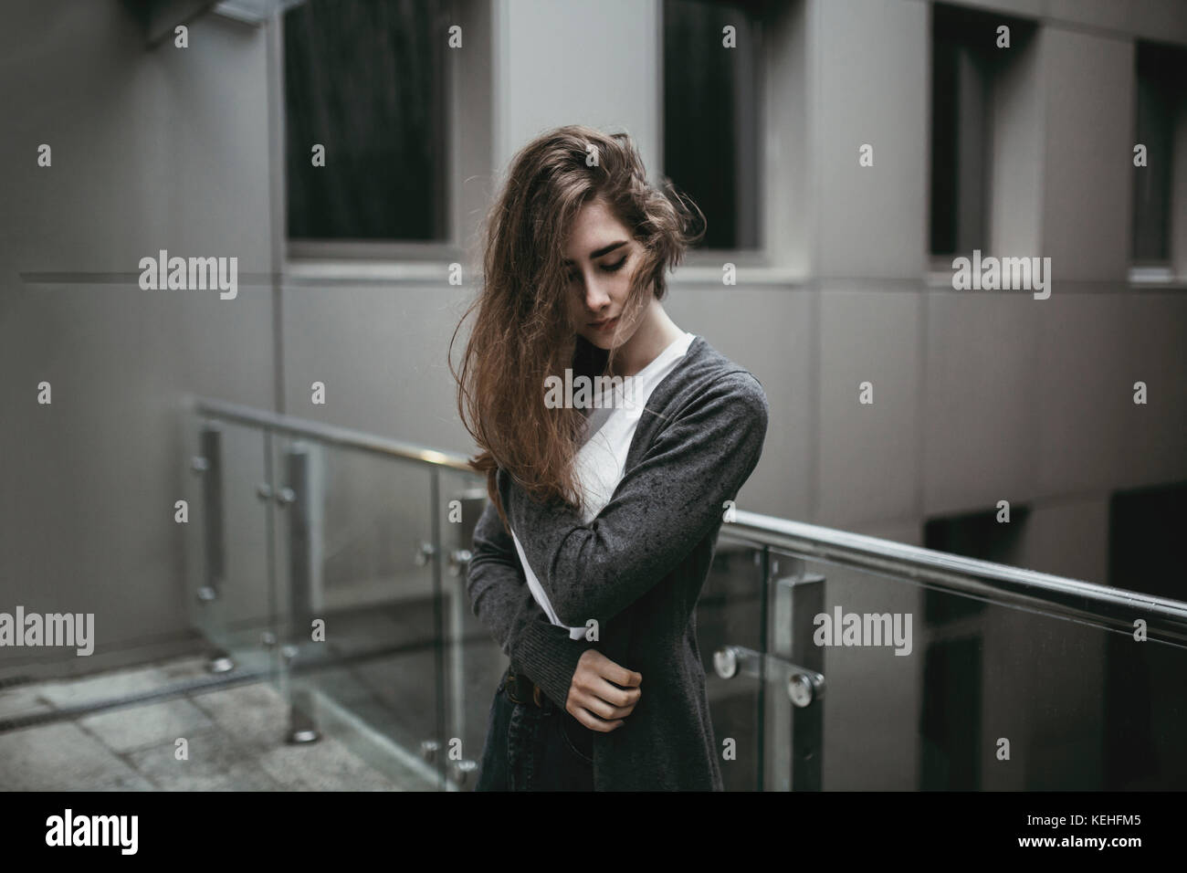 Pensive Caucasian woman standing near railing Stock Photo - Alamy