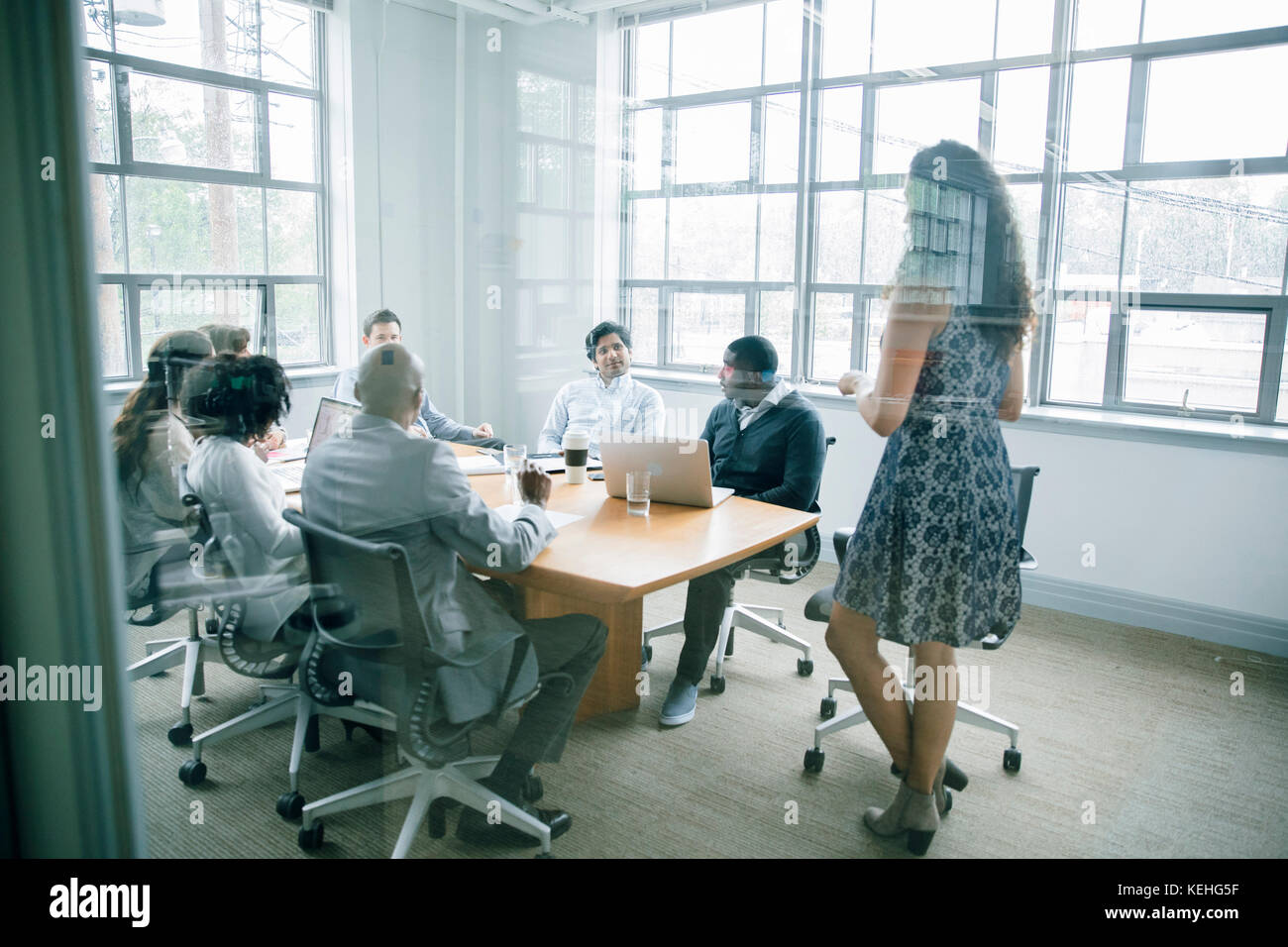 Businesswoman talking behind window in meeting Stock Photo - Alamy