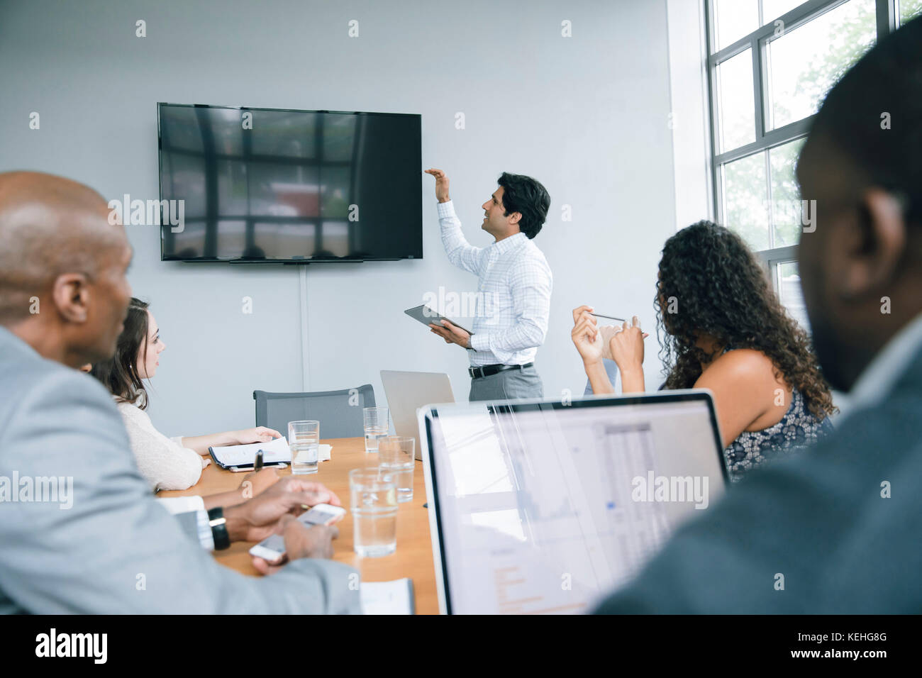Businessman talking near visual screen in meeting Stock Photo - Alamy
