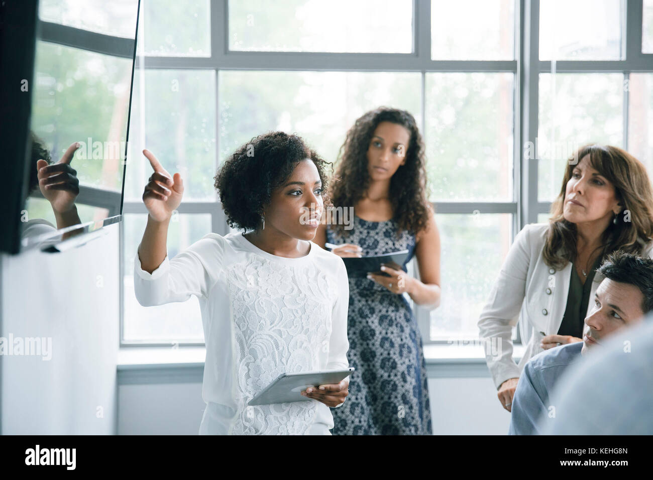 Businesswoman talking near visual screen in meeting Stock Photo - Alamy
