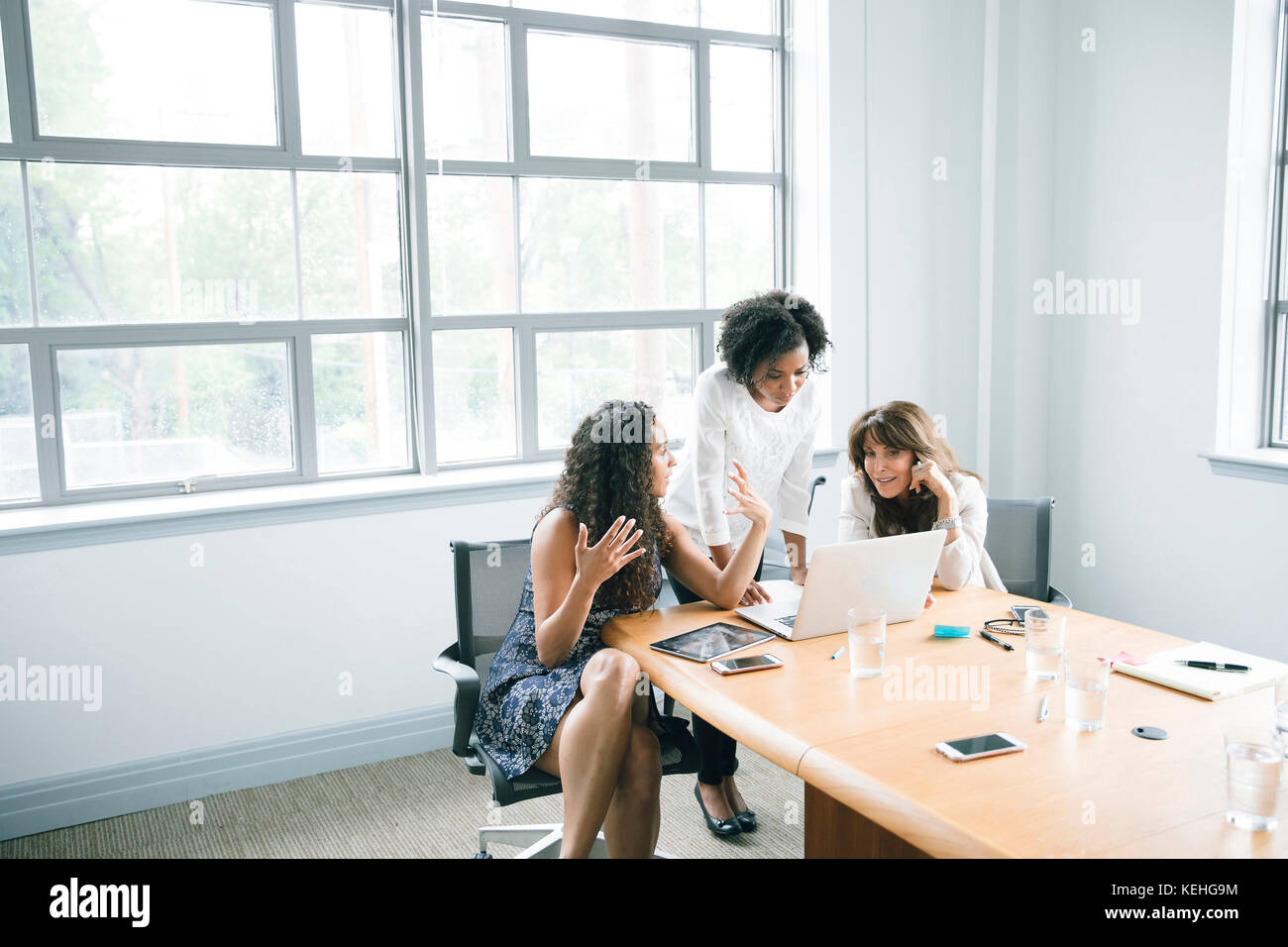 Businesswomen using laptop in meeting Stock Photo - Alamy