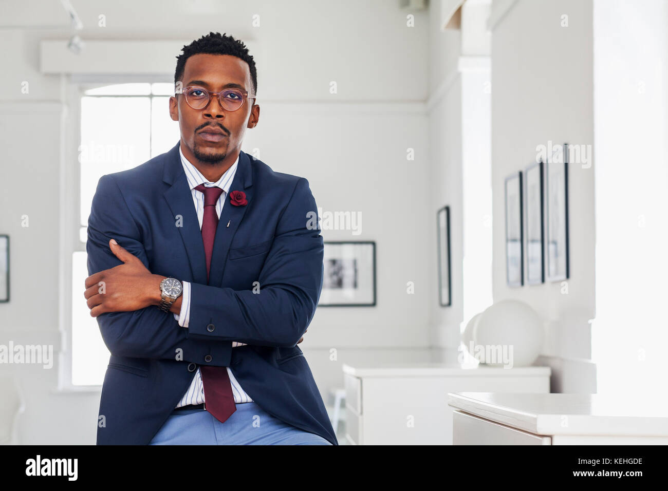 Black man with arms crossed in gallery Stock Photo - Alamy