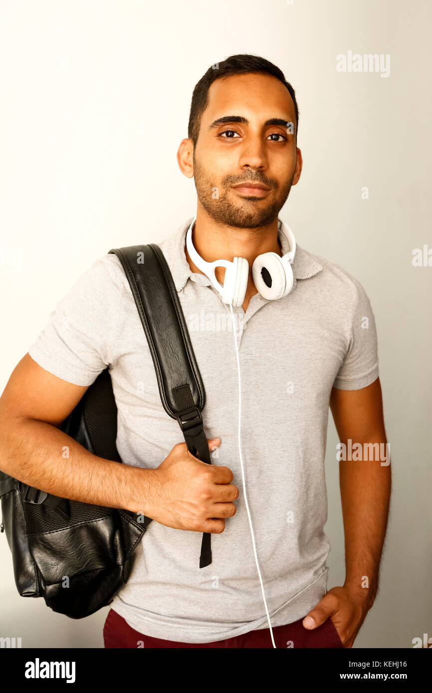 Portrait of nixed race man with headphones and backpack Stock Photo - Alamy