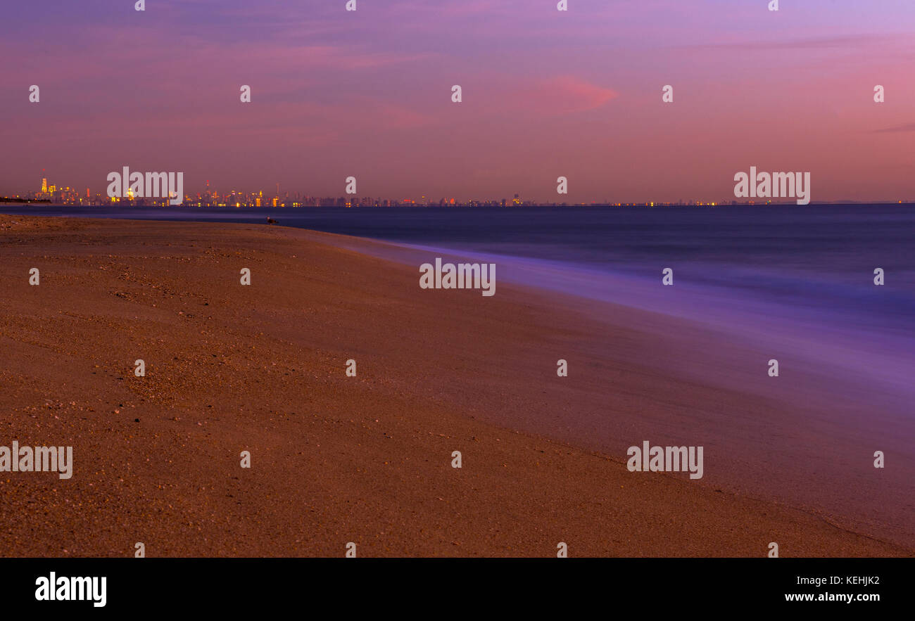 Half sea and half sand foreground with NYC skyline on the background ...